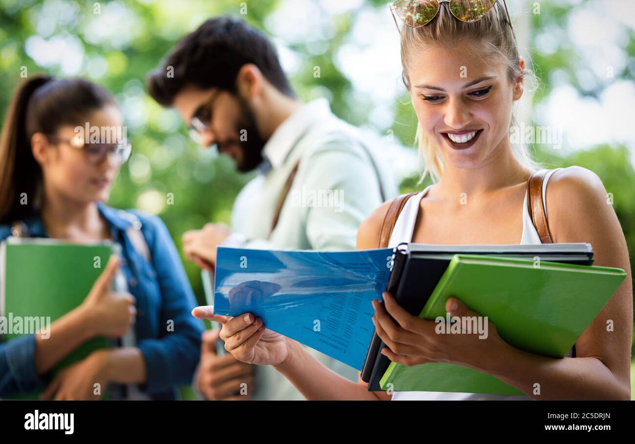 Happy young university students friends studying with books at ...