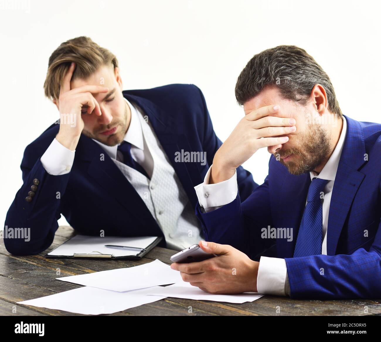 Overworked office workers. Men with tired, worried faces read about ...