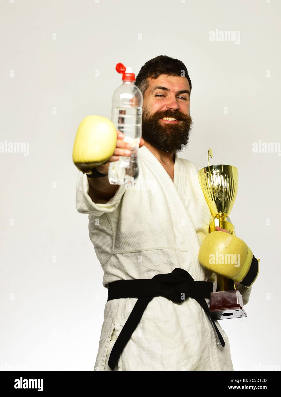 Man with beard in kimono on white background. Combat master celebrates ...