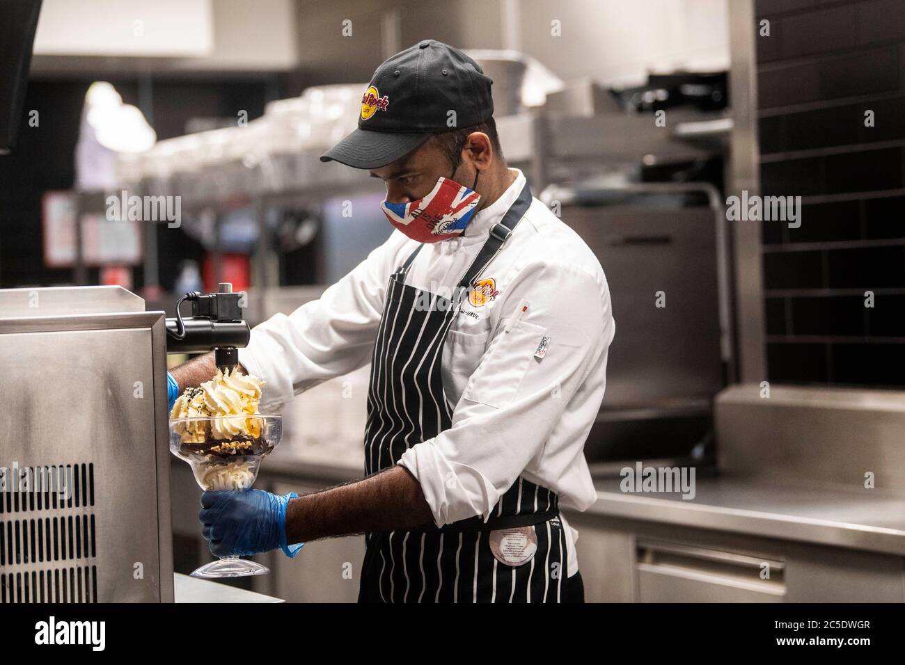 A chef wears PPE as he makes a chocolate brownie in the kitchen of the ...