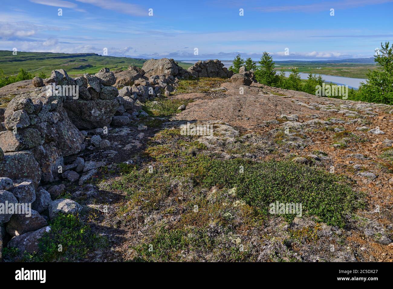 Basalt rock formations and trees by an old stone wall marking the ...