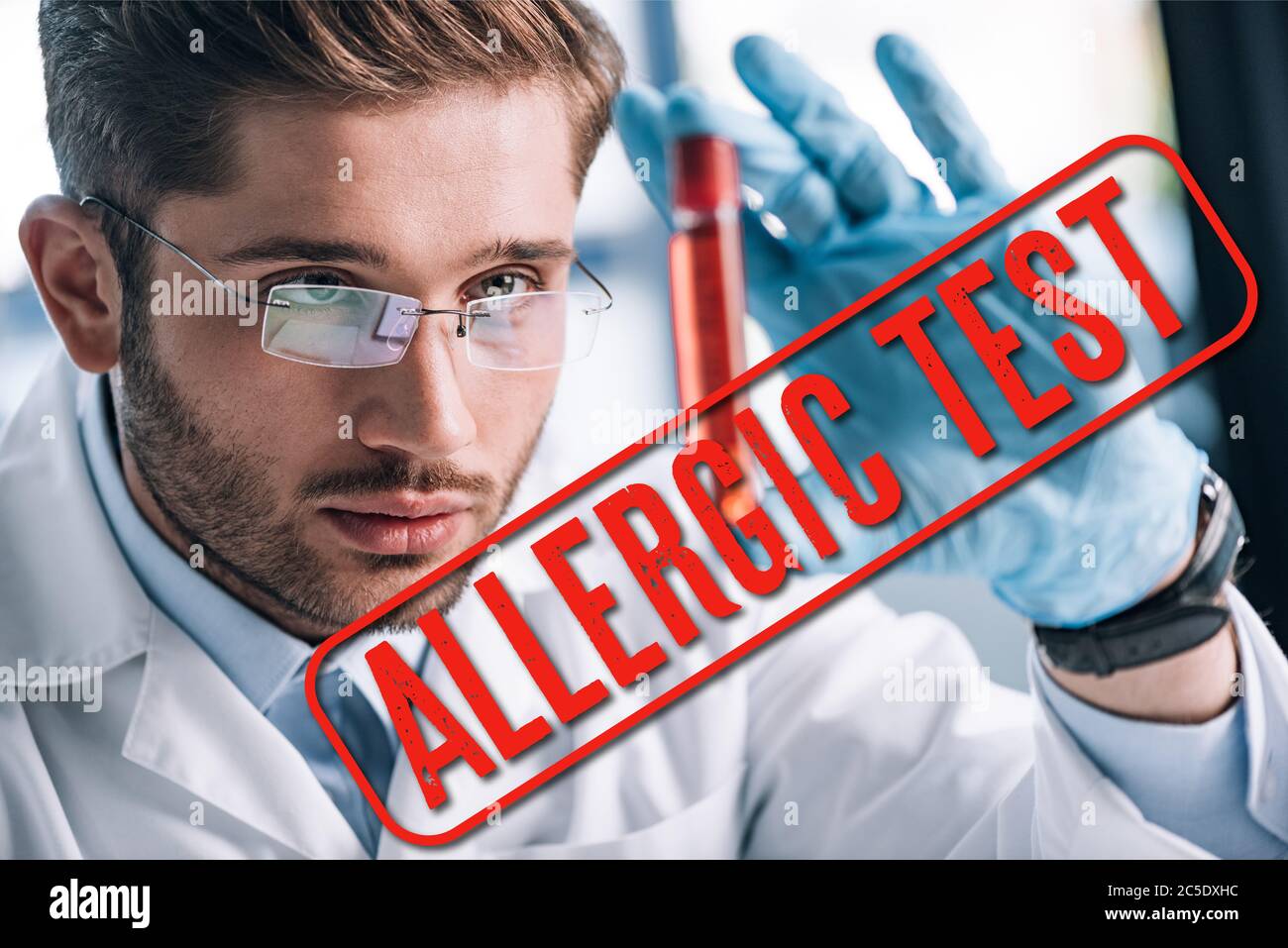 selective focus of bearded allergist in glasses holding test tube with ...