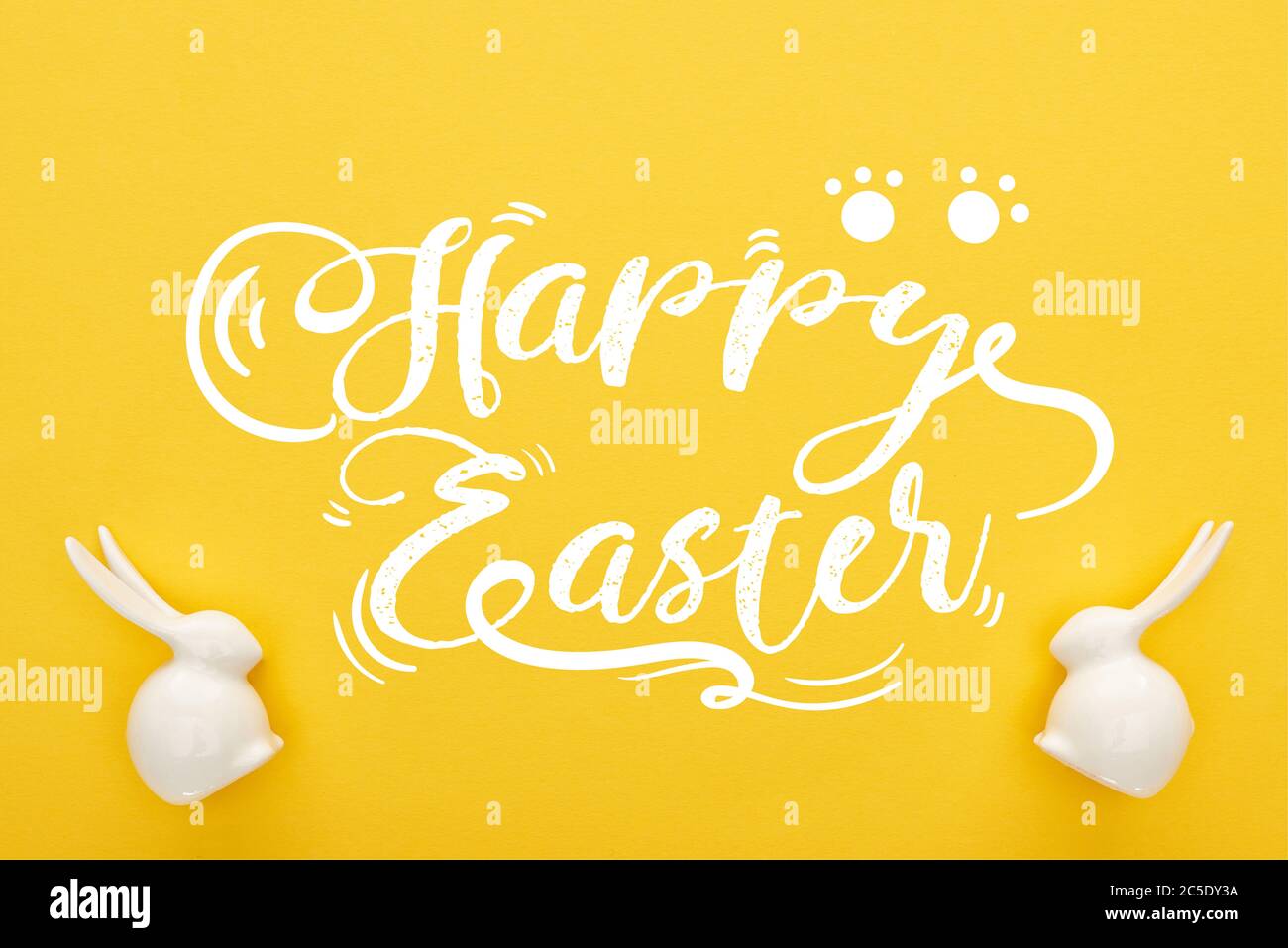 top view of white Easter bunnies on colorful yellow background with ...