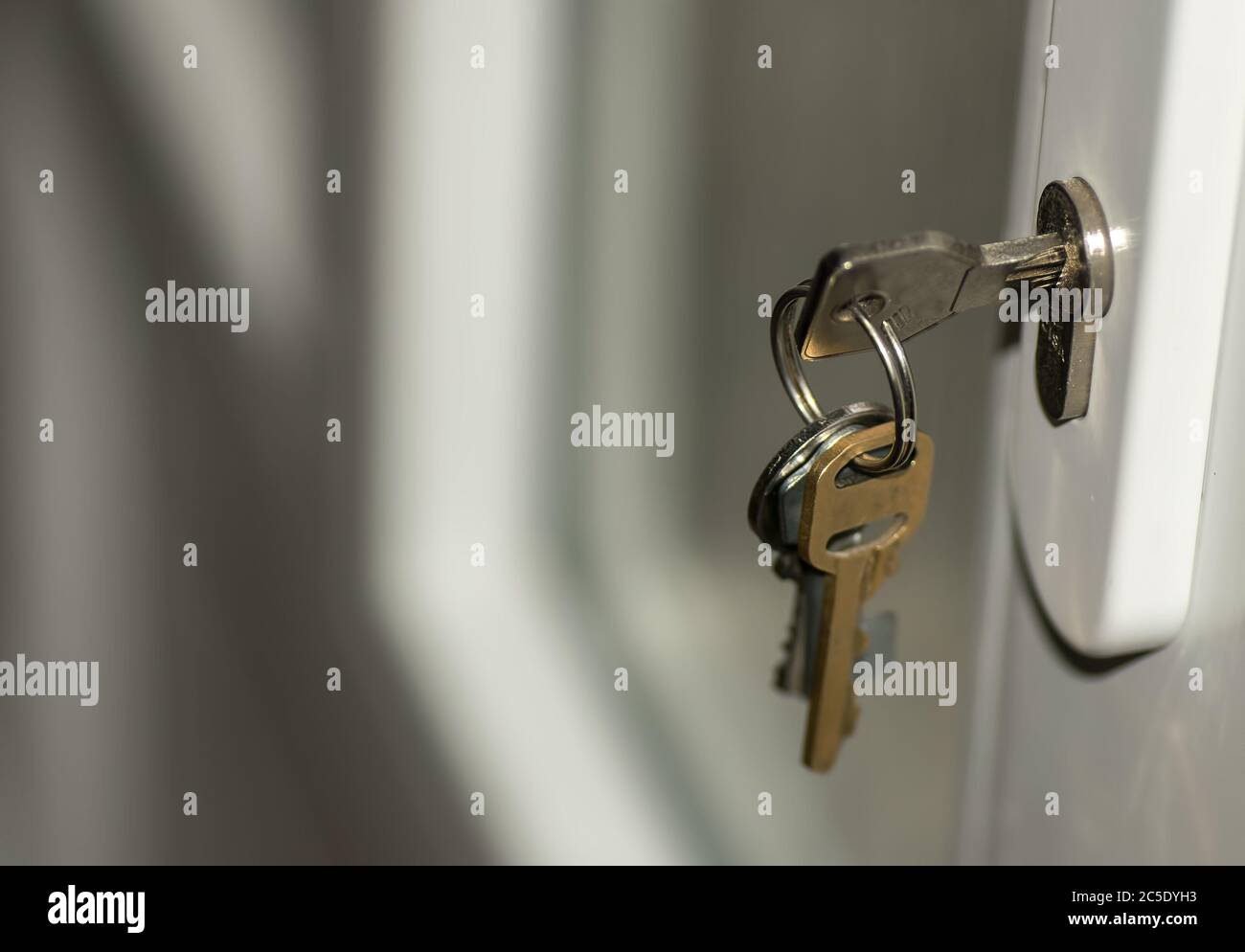 Closeup image of house keys in lock Stock Photo - Alamy