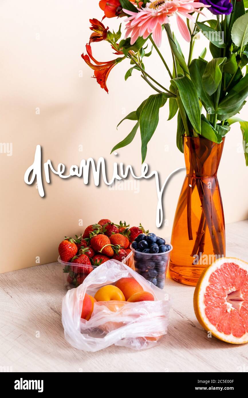 floral and fruit composition with berries, grapefruit and apricots near ...