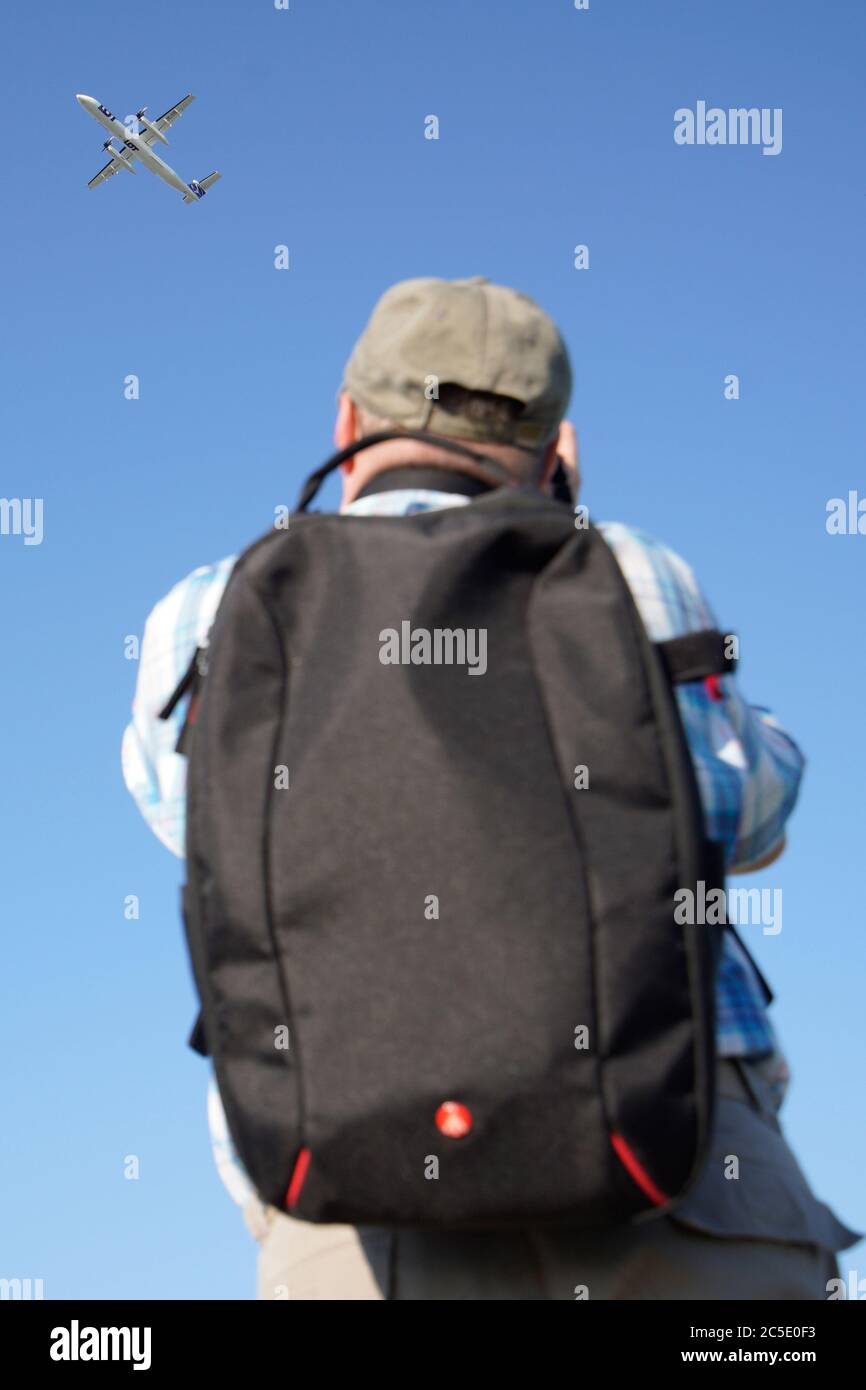An airplane spotter is seen taking a photograph of a passing airplan on ...