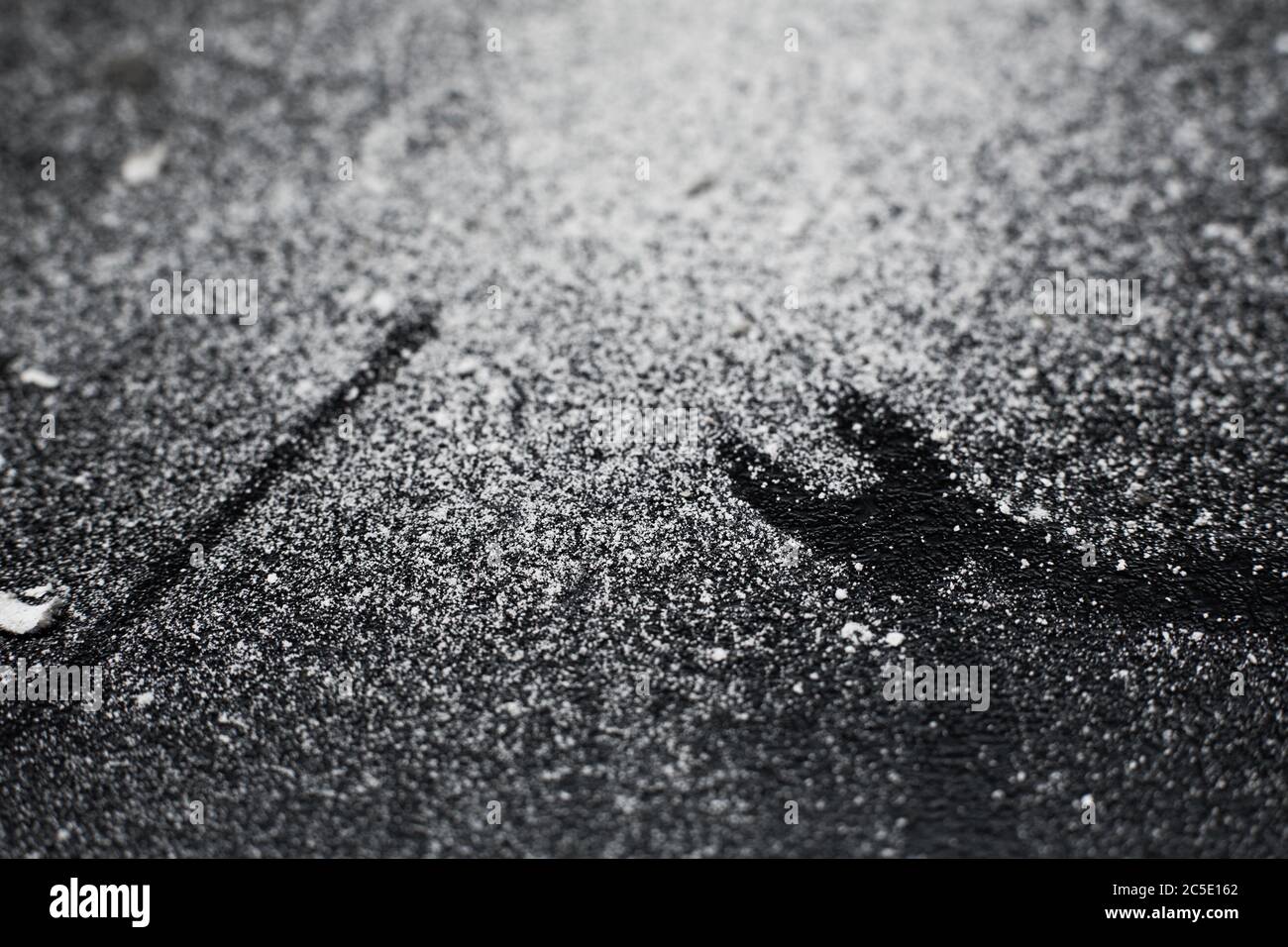 Traces of tools on a black table dusted with white dust Stock Photo - Alamy
