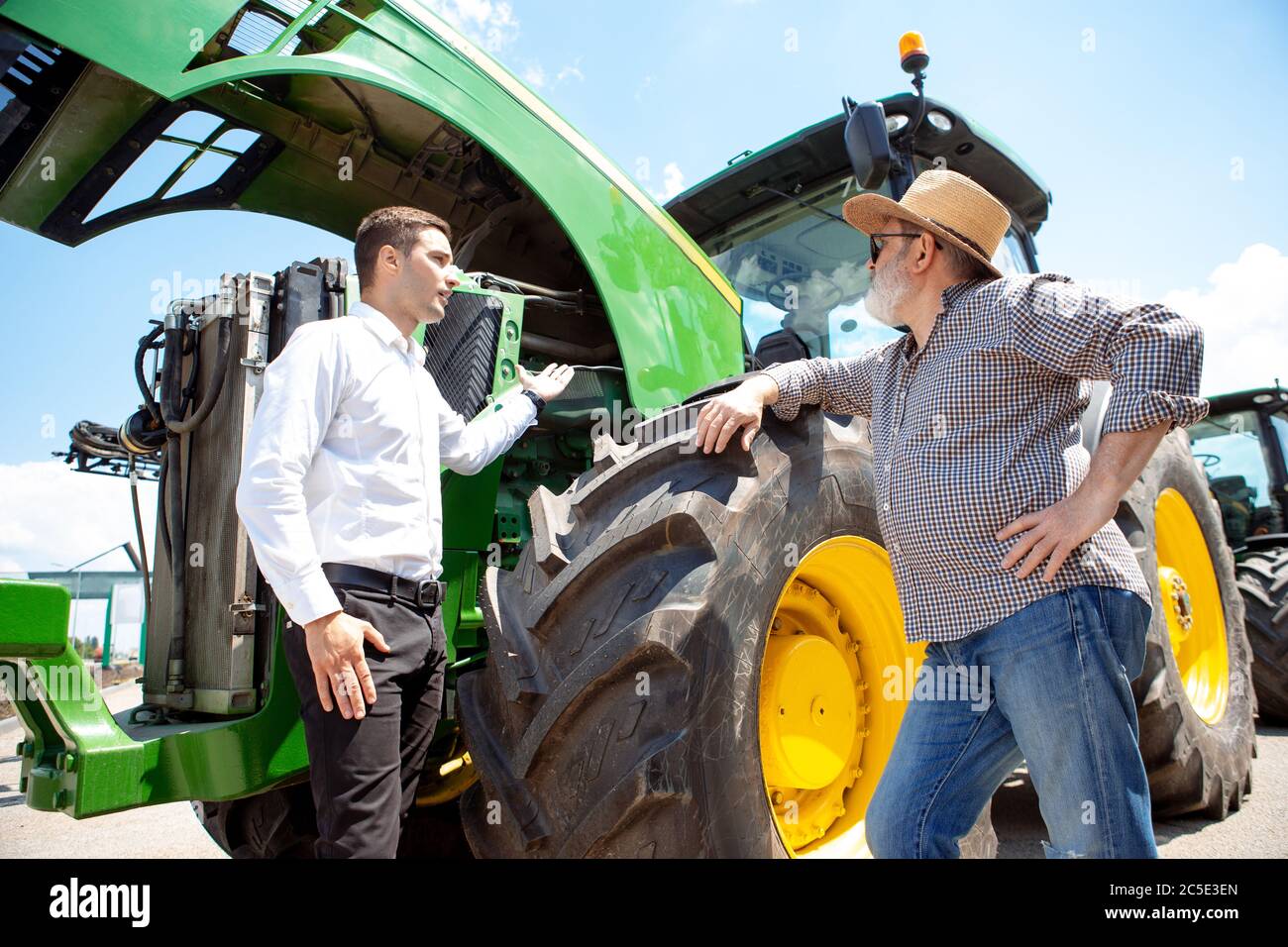 Professional farmer with a modern tractor, combine at a field in ...