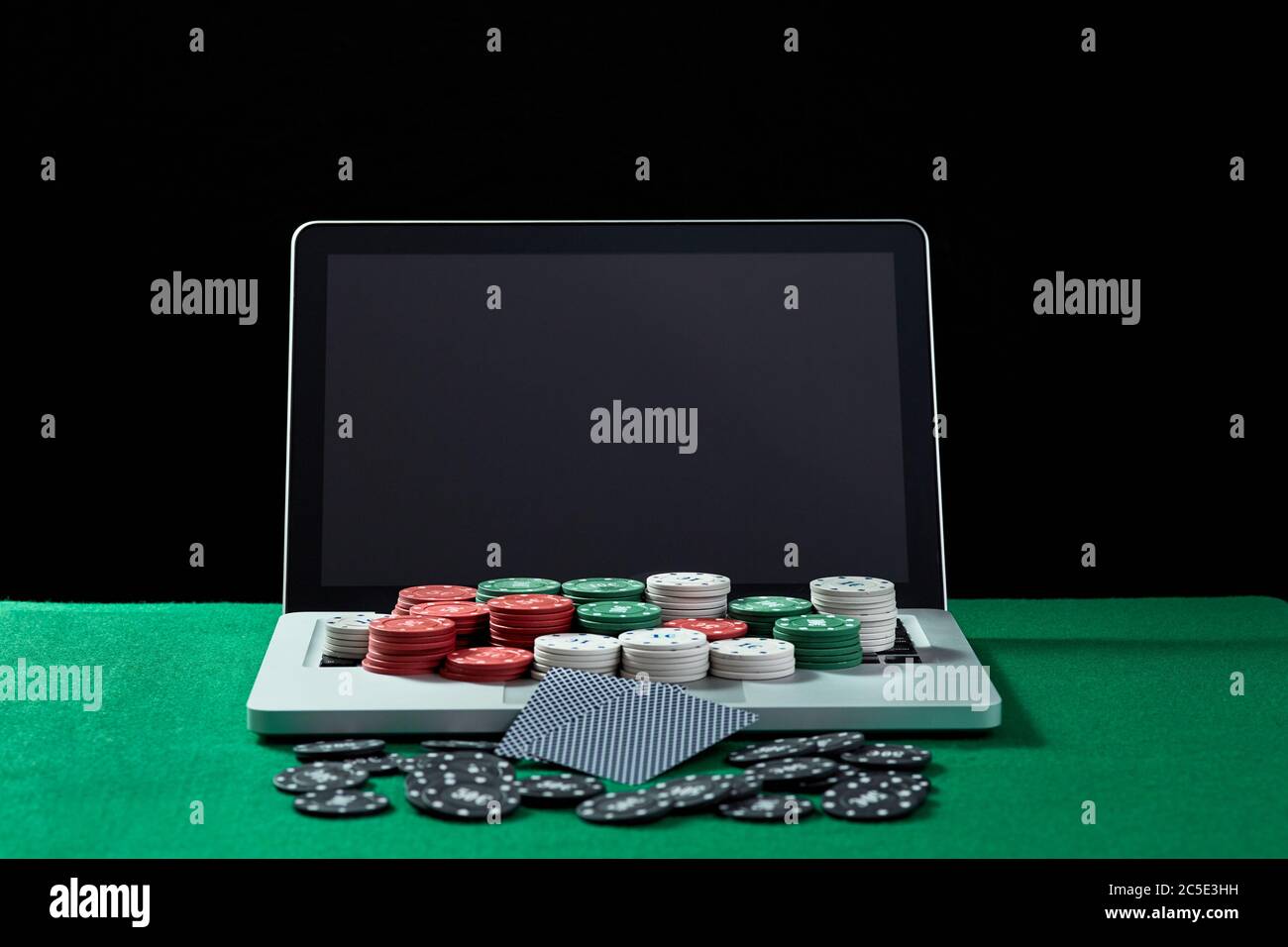 Casino chips and cards on keyboard notebook at green table Stock Photo ...