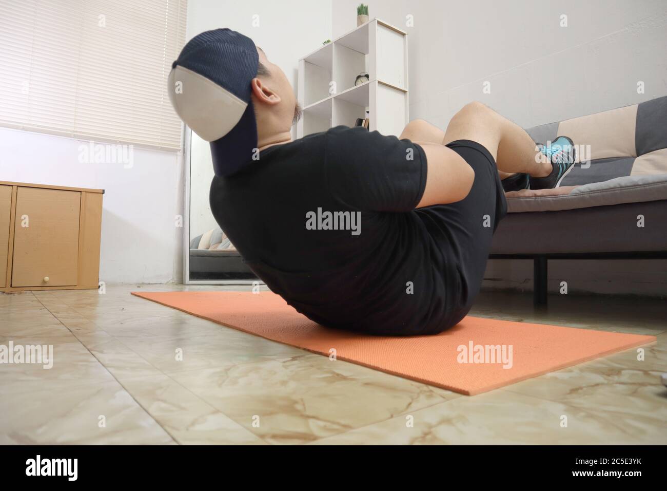 Asian male doing exercise at home to stay healthy on new normal ...