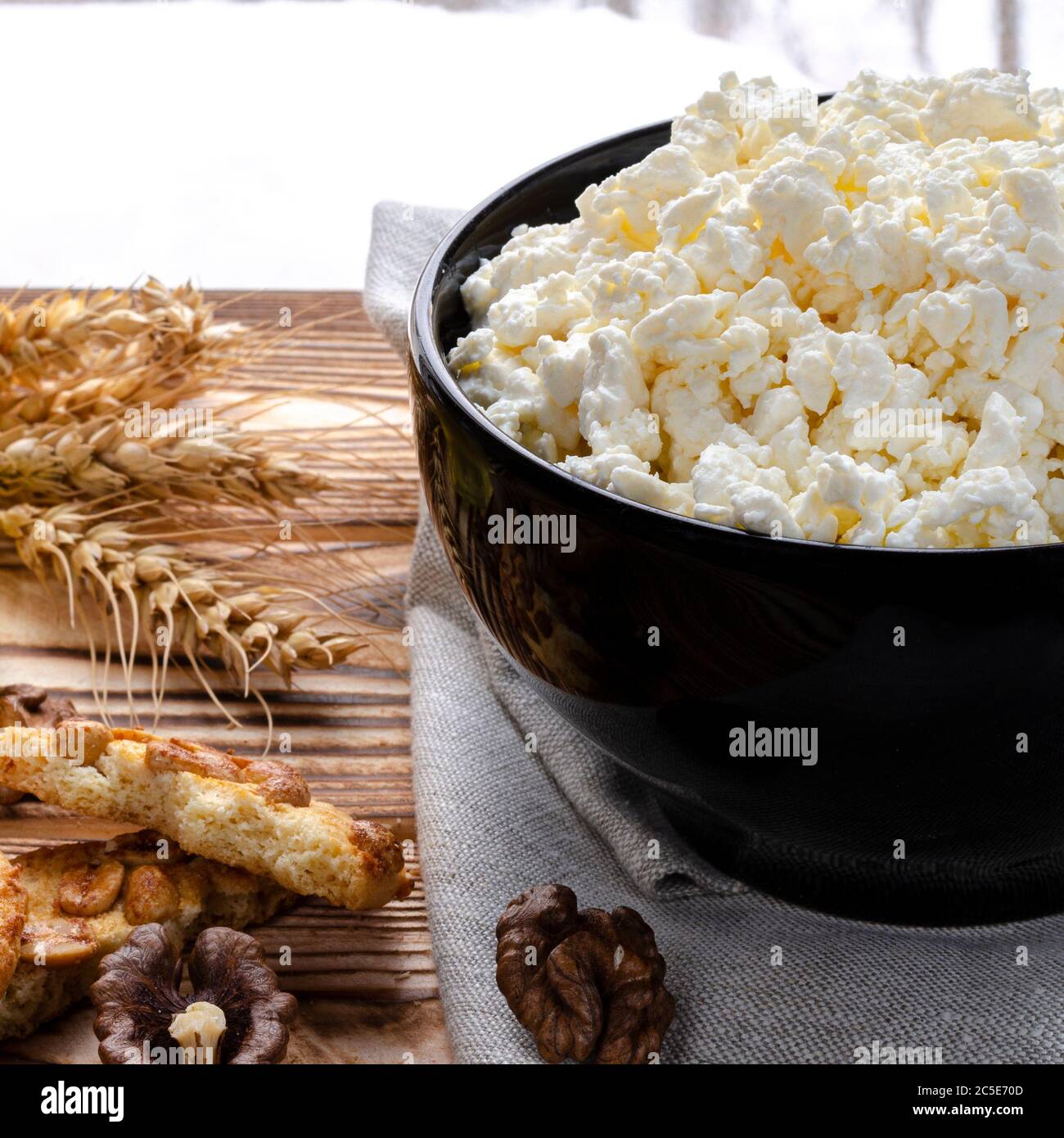 Organic food. The textured curd lies in a black plate next to honey ...