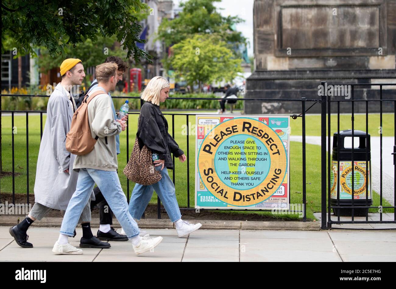 Members of the public walk past a sign that reads "Please respect ...