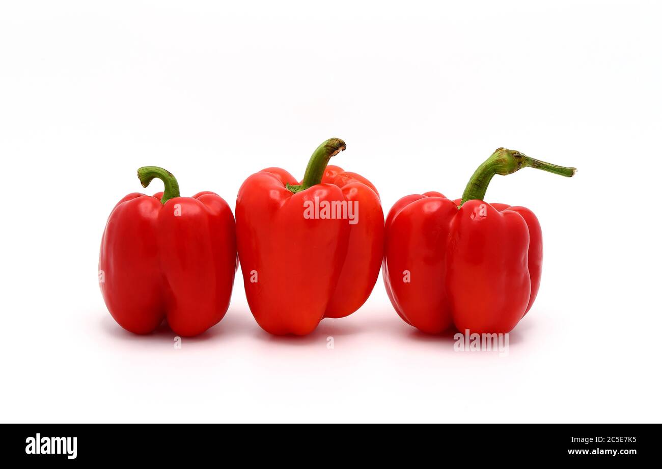 Three red ripe sweet peppers on a light background. Natural product ...
