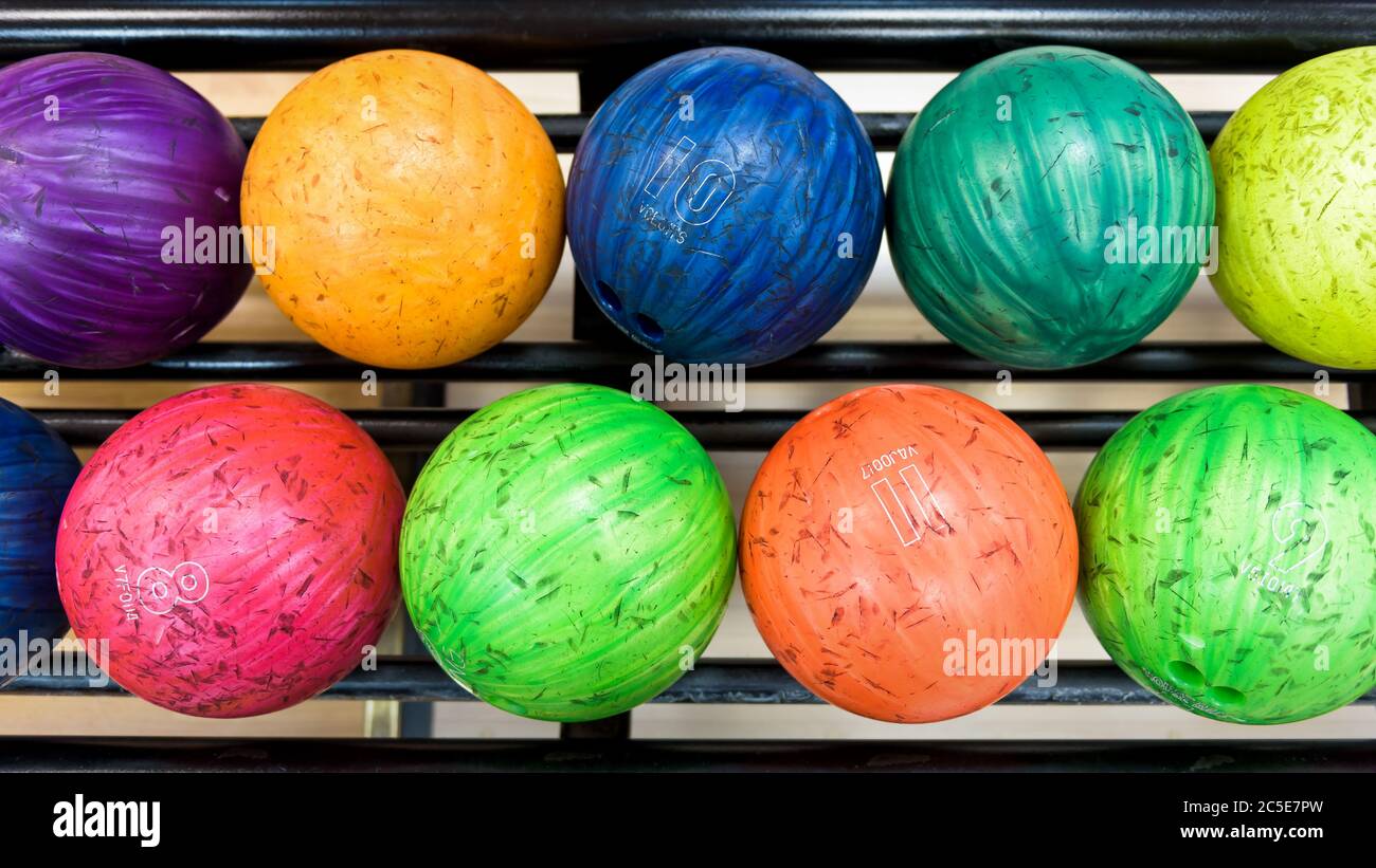 Colorful bowling balls in return machine Stock Photo - Alamy