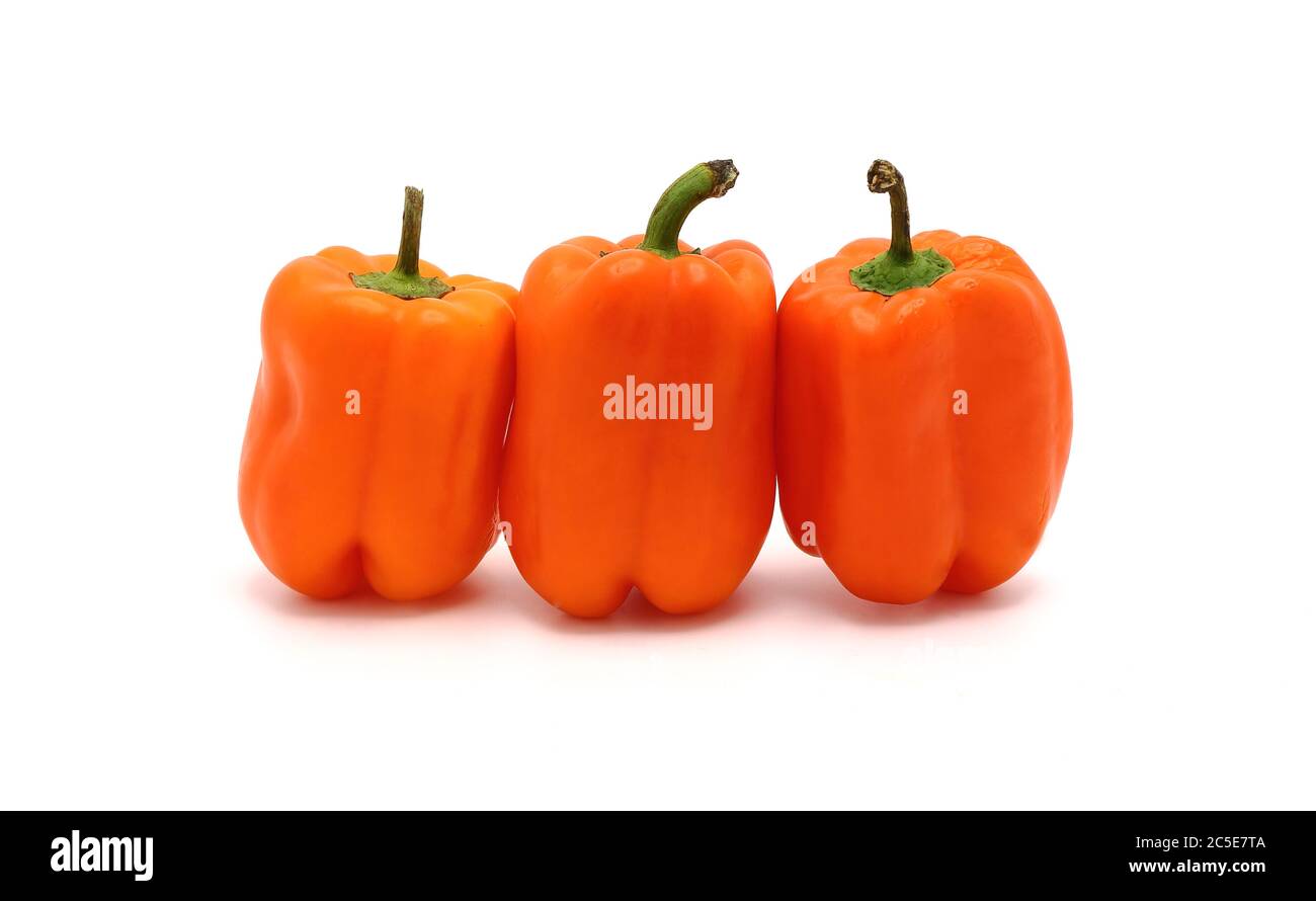 Three ripe sweet orange peppers on a light background. Natural product ...
