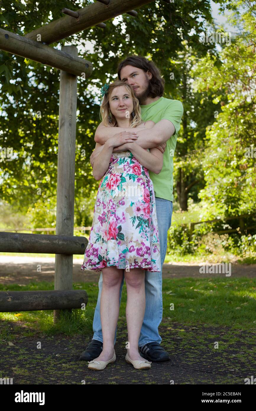 Embracing young lovers in park on a sunny summer day, Springfield Park ...