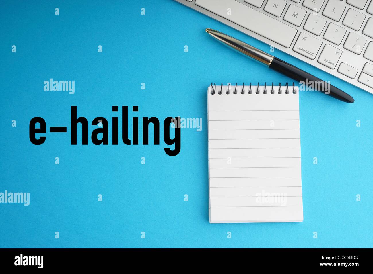 E HAILING text with fountain pen, keyboard and notepad on blue ...