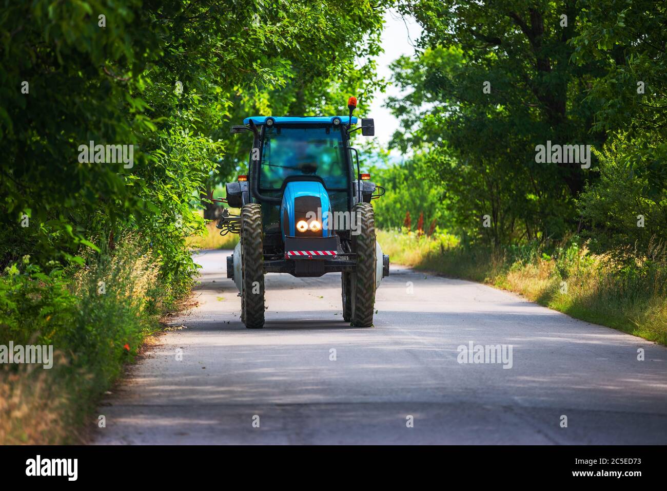 Farming tractor on the road Stock Photo - Alamy