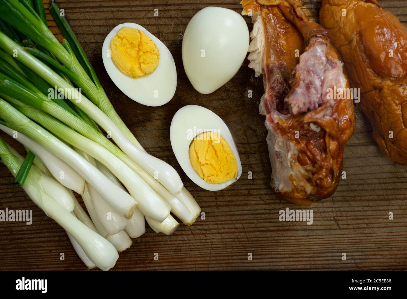 Boiled eggs, fresh chives and smoked chicken laid out on a board Stock ...