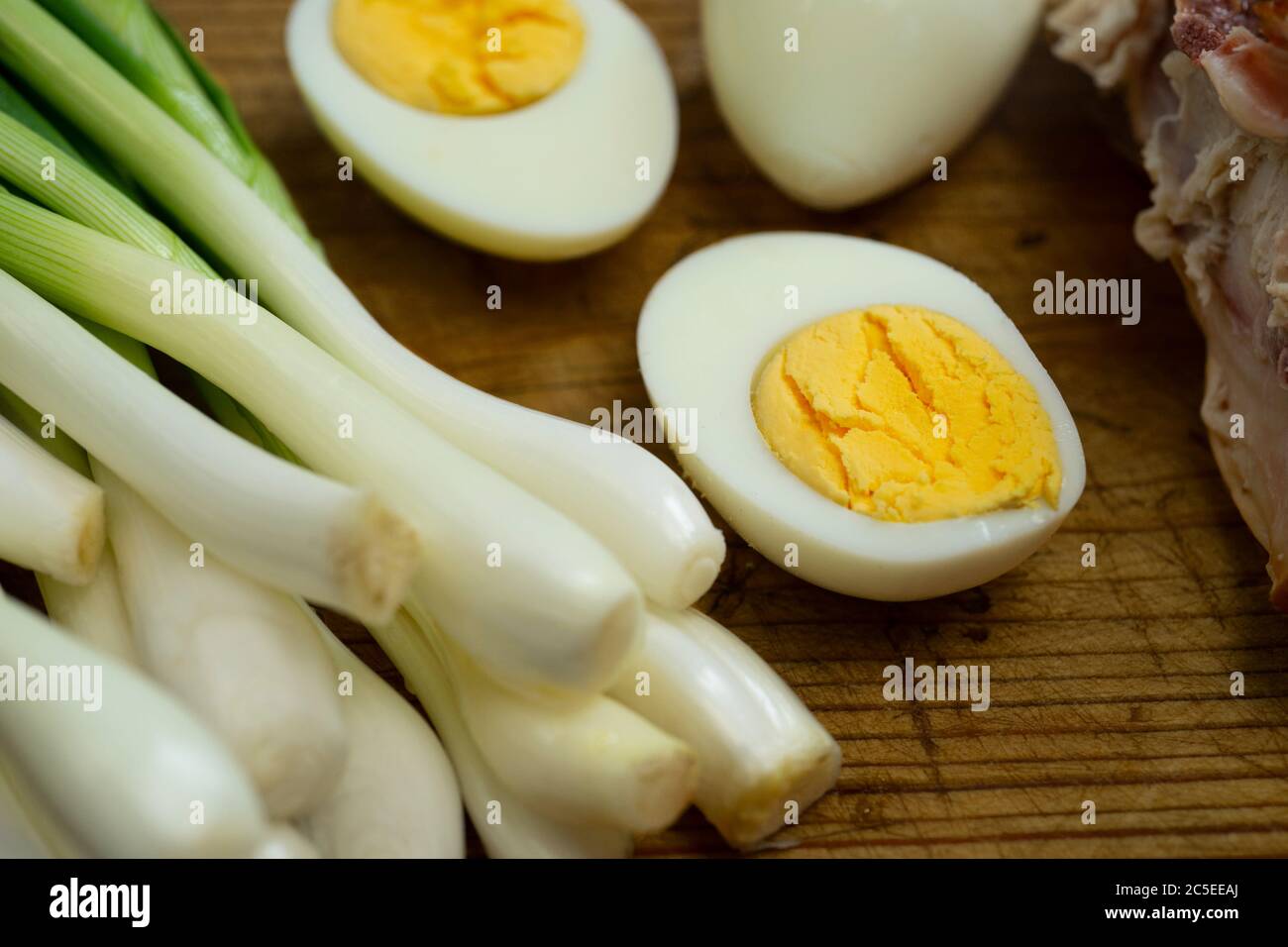 Boiled eggs, fresh chives and smoked chicken laid out on a board Stock ...