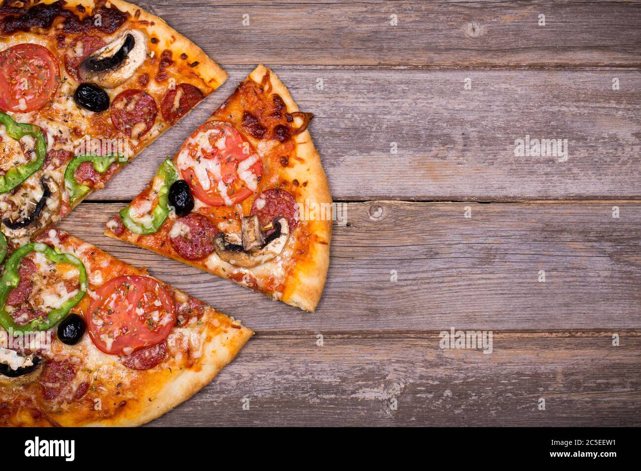 Pepperoni pizza with sliced vegetables on rustic wood background Stock ...