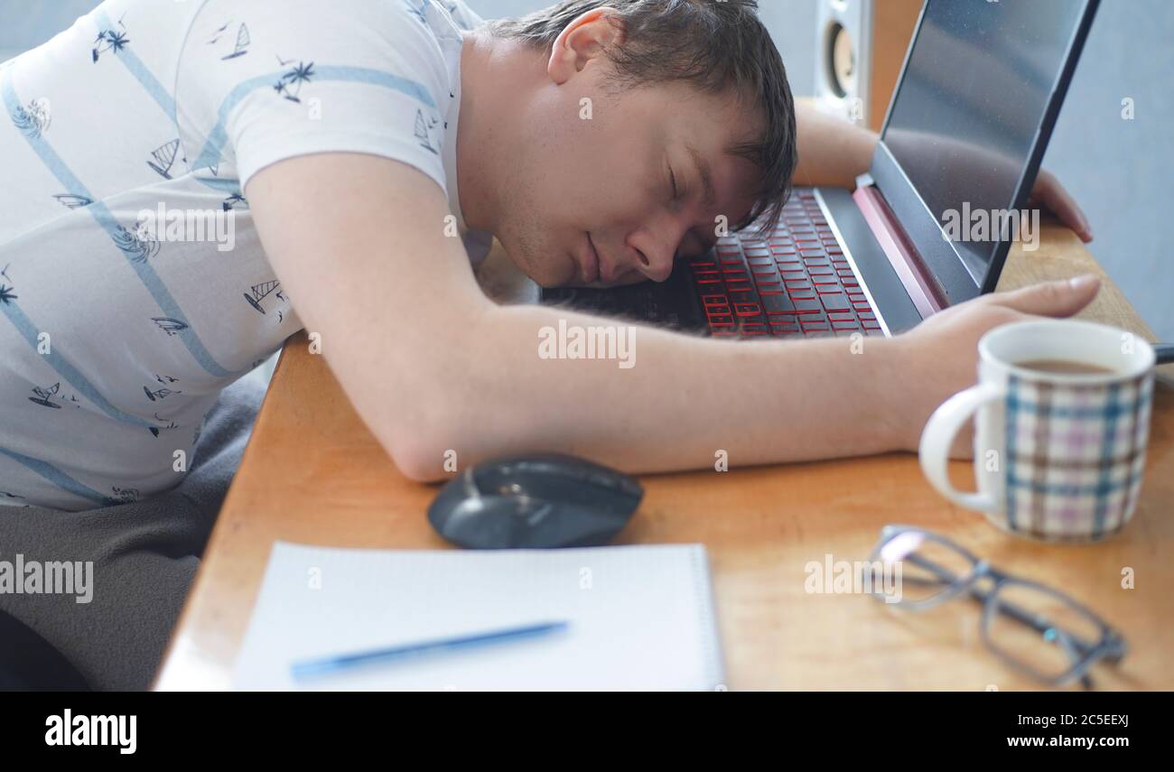 Tired of hard work student guy sleeping on laptop at table Stock Photo ...