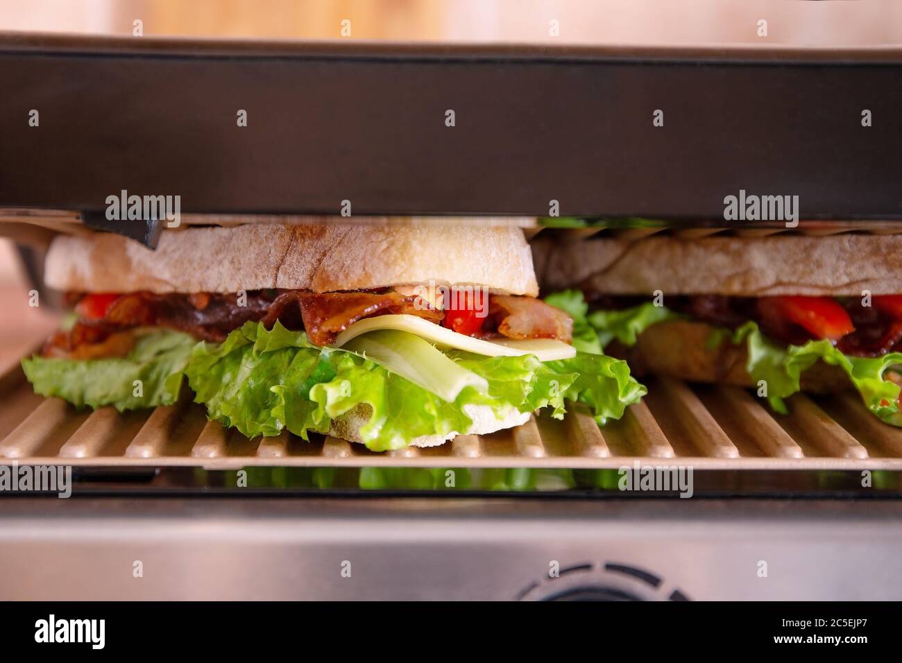 A sandwich or long panini stuffed with lettuce, tomato and cheese with ...