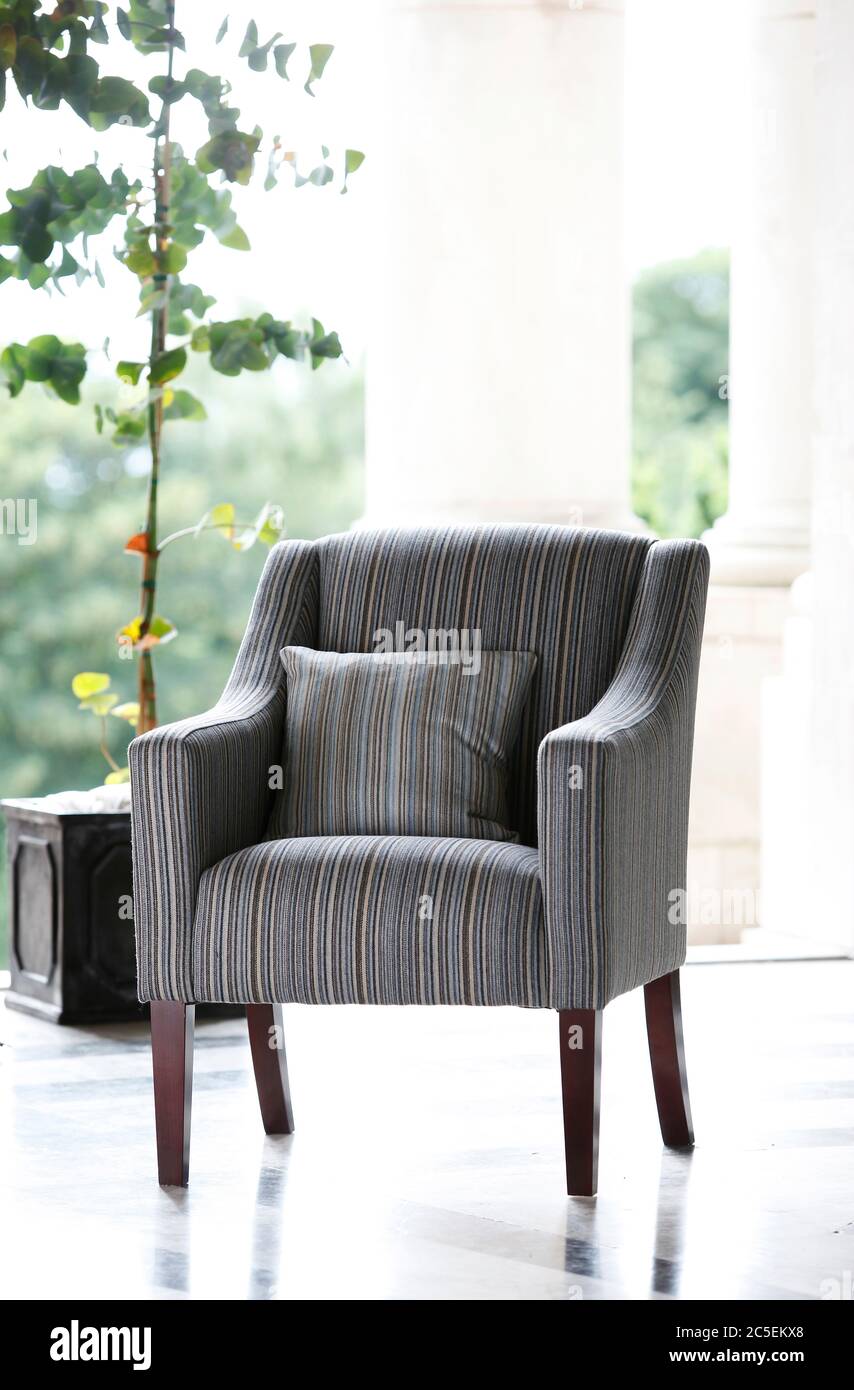 Shot of a cozy arm chair in living room Stock Photo - Alamy