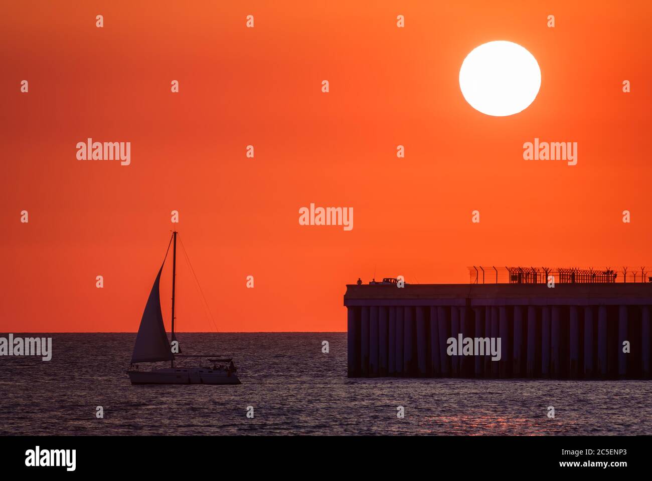 Beautiful red and orange sunset over the sea in a cloudy sky. The sun goes down over the sea ...