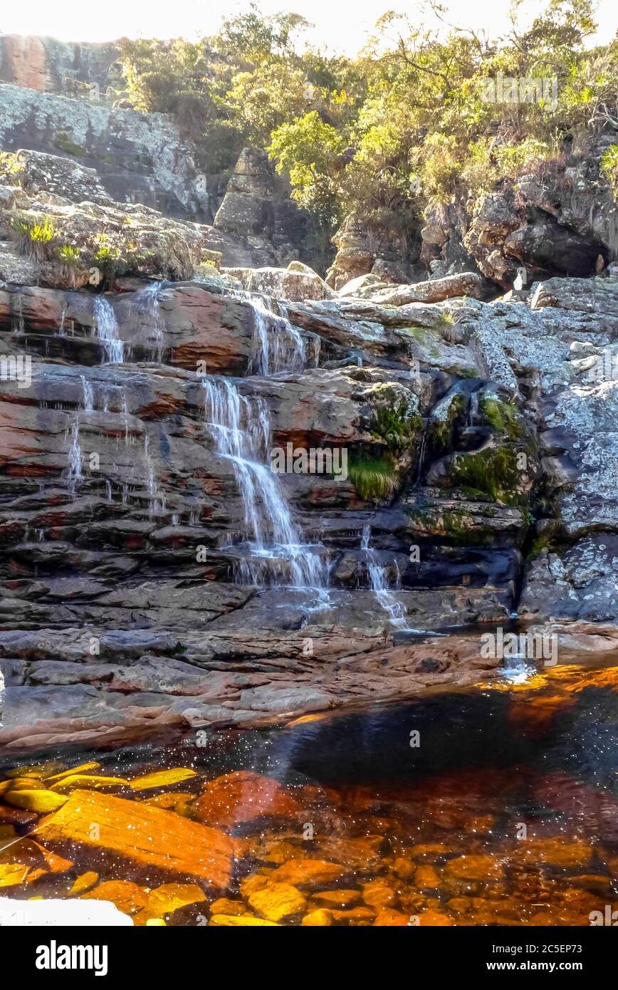 Cascatinha waterfall, flowing between large rocks and with a small rust ...