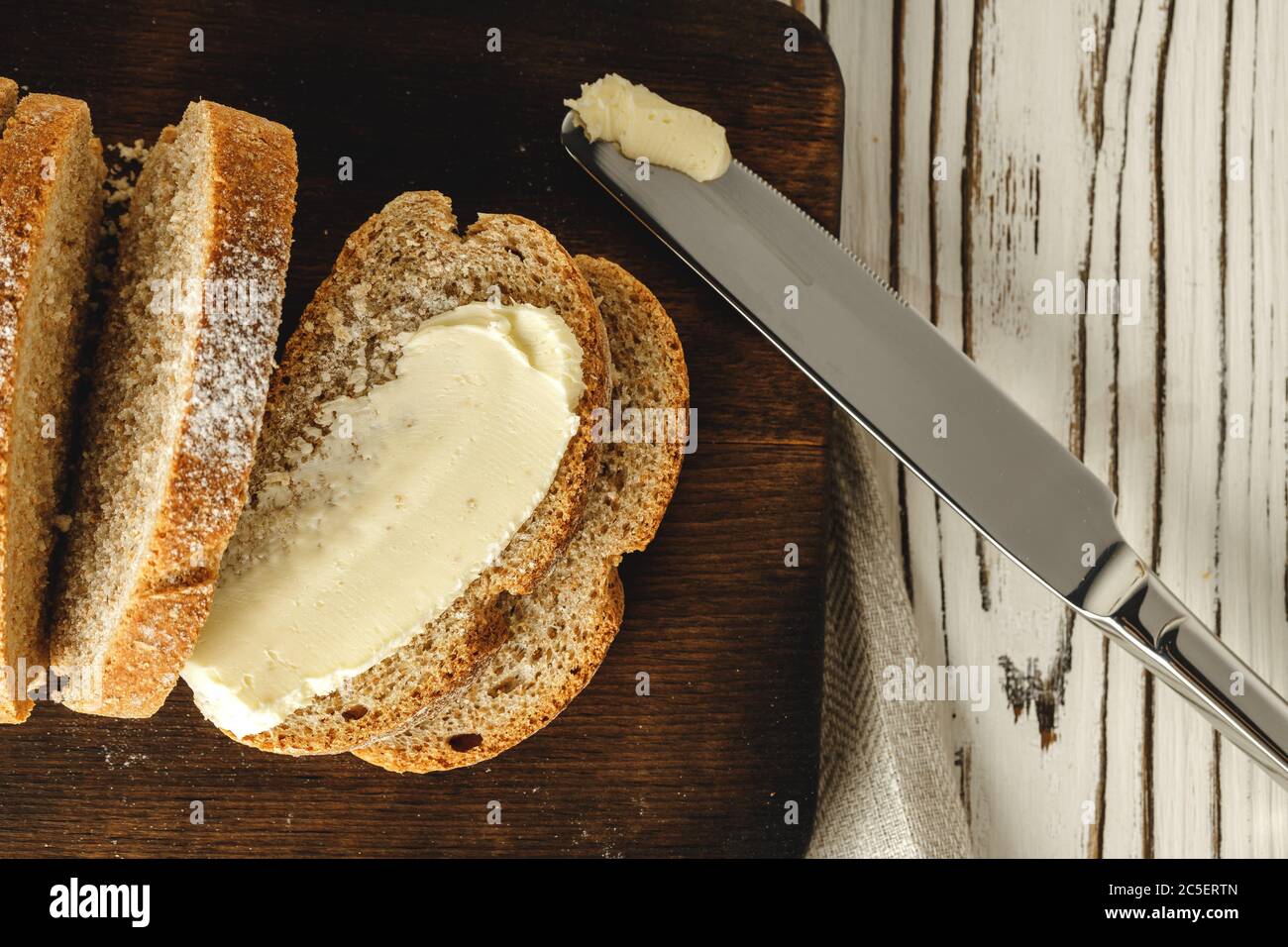 Buttered slice of rye bread on wooden table Stock Photo - Alamy