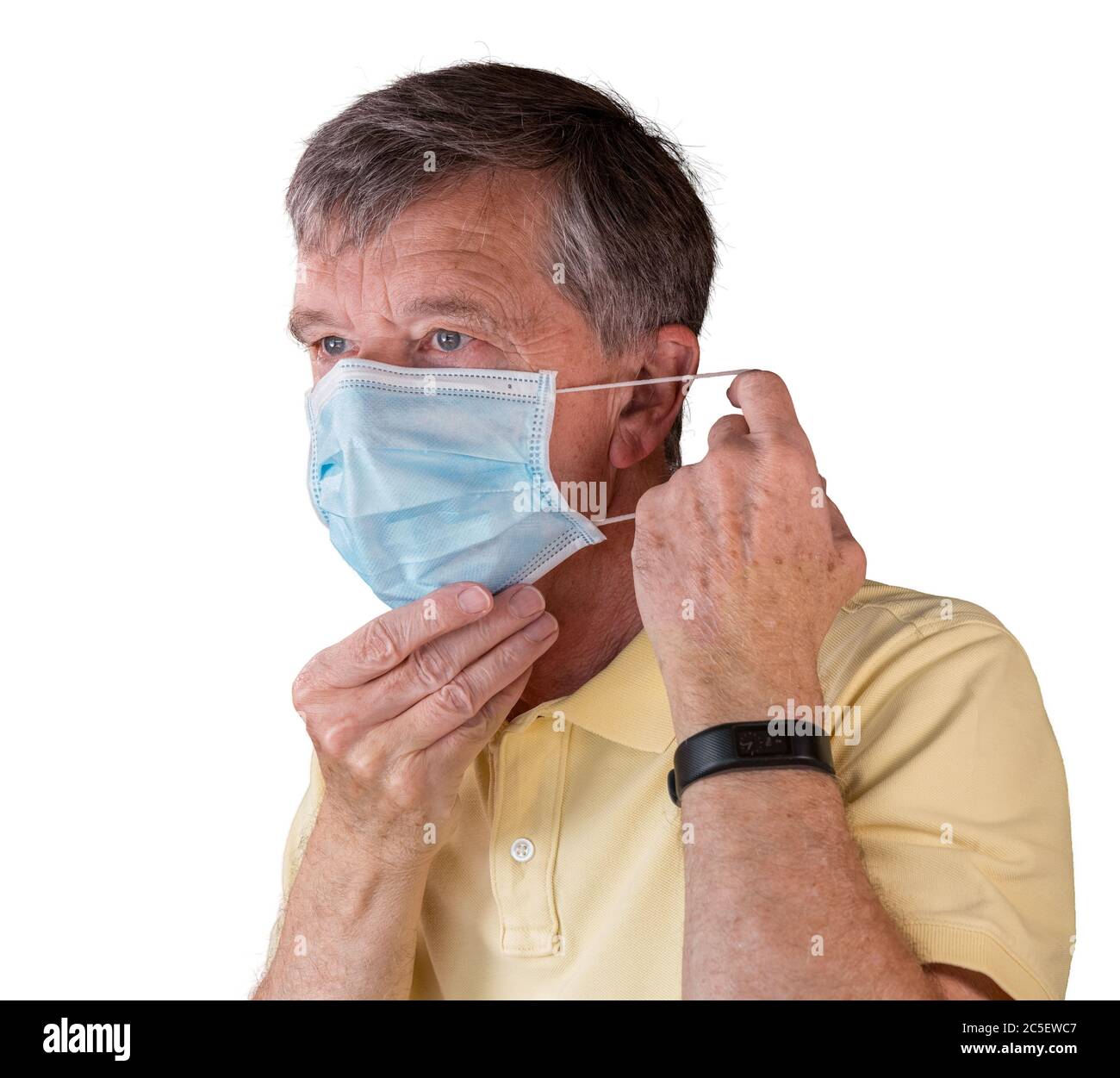 Senior caucasian man adjusting his face mask and looking very tense and ...