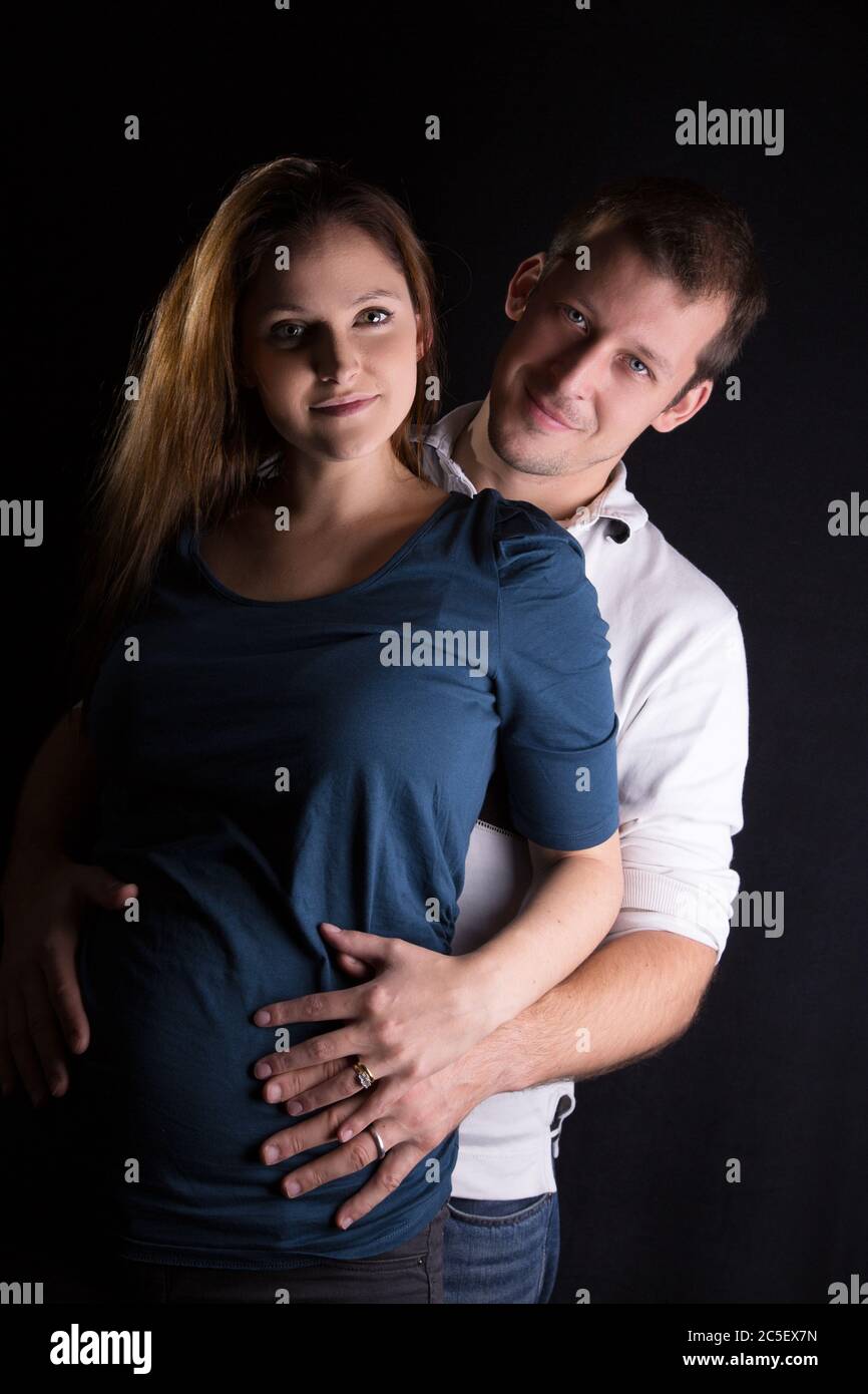 Attractive young parents to be hold their hands over their unborn child ...