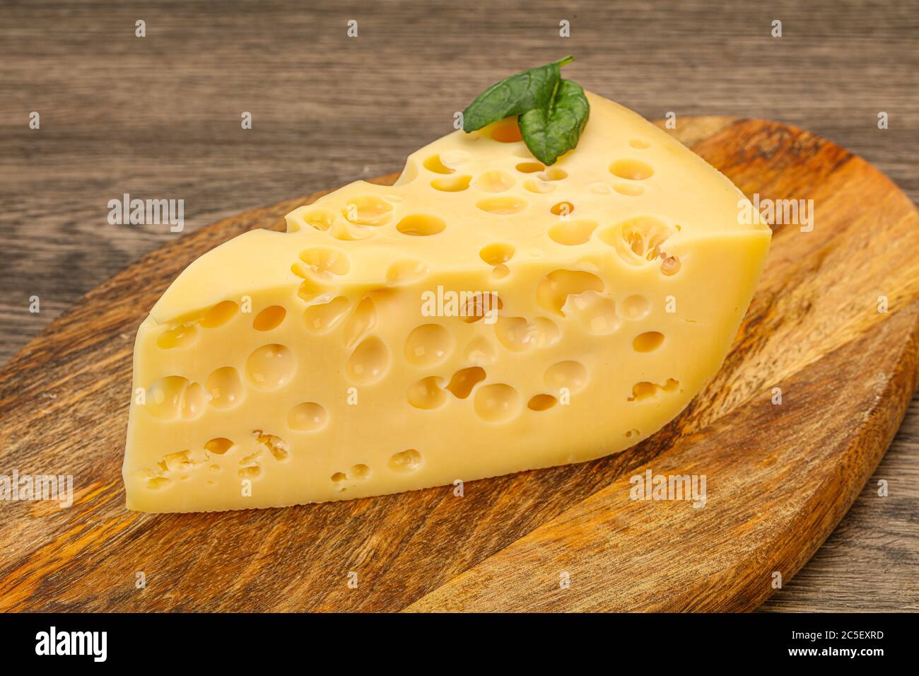 Maasdam cheese - dairy yellow triangle with holes Stock Photo - Alamy