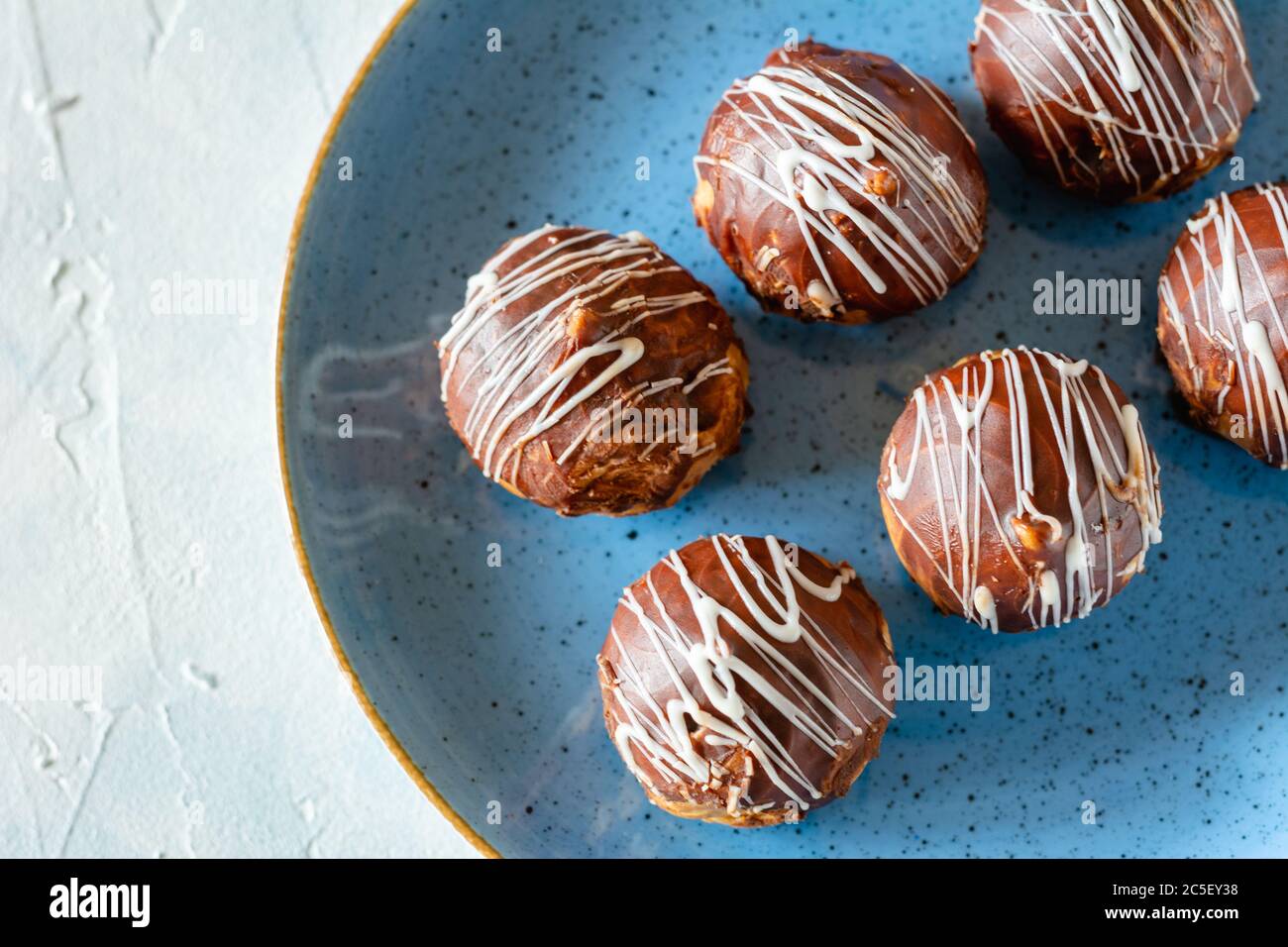 Mini puff cakes with vanilla pudding topped with chocolate Stock Photo ...