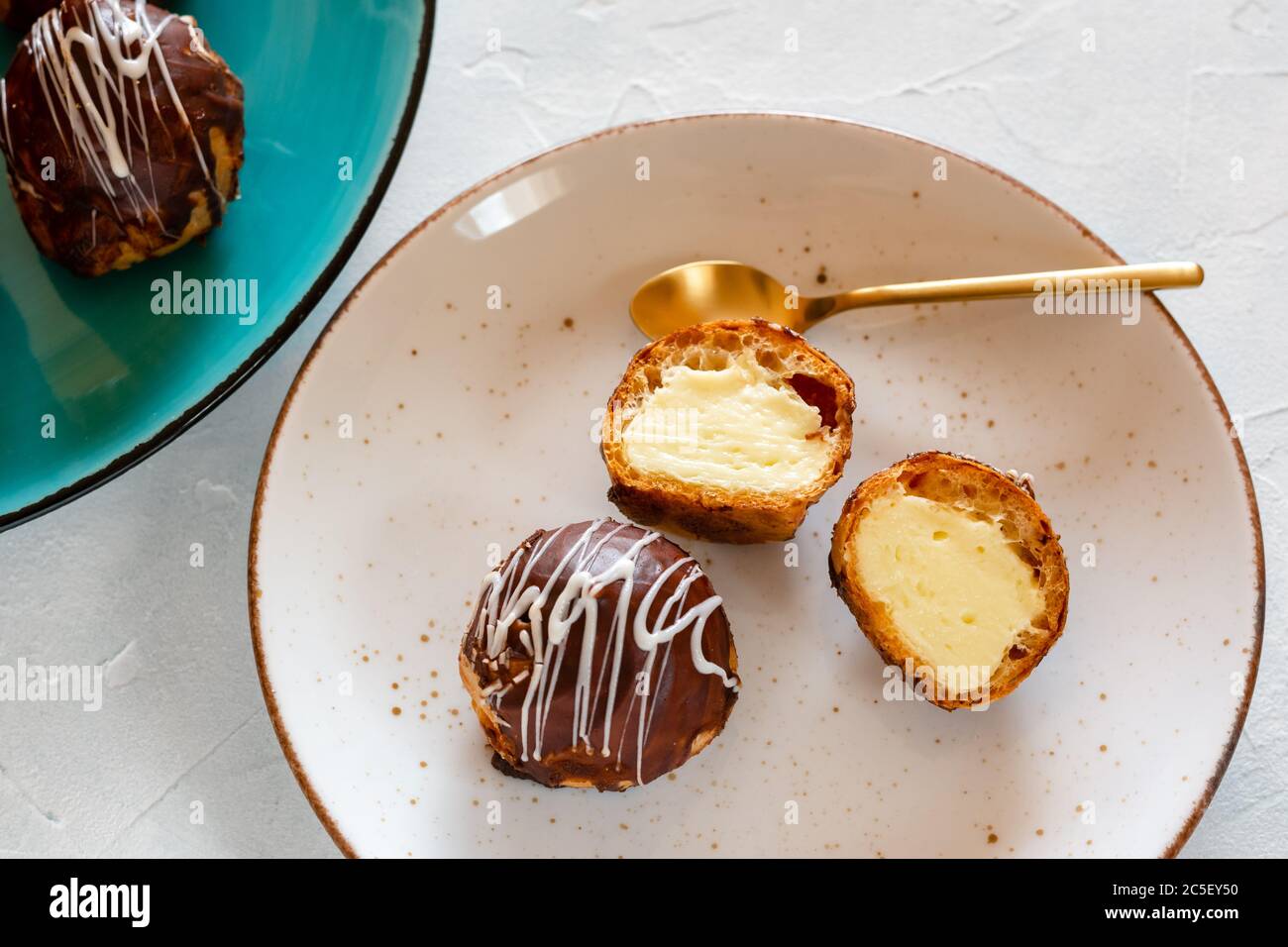 Mini puff cakes with vanilla pudding topped with chocolate Stock Photo ...