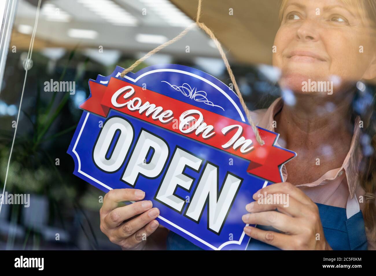 Happy Female Store Owner Turning Open Sign in Window Stock Photo - Alamy