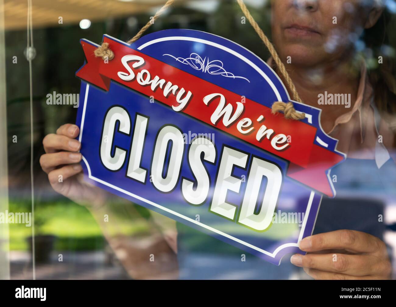 Sad Female Store Owner Turning Sign to Closed in Window Stock Photo - Alamy
