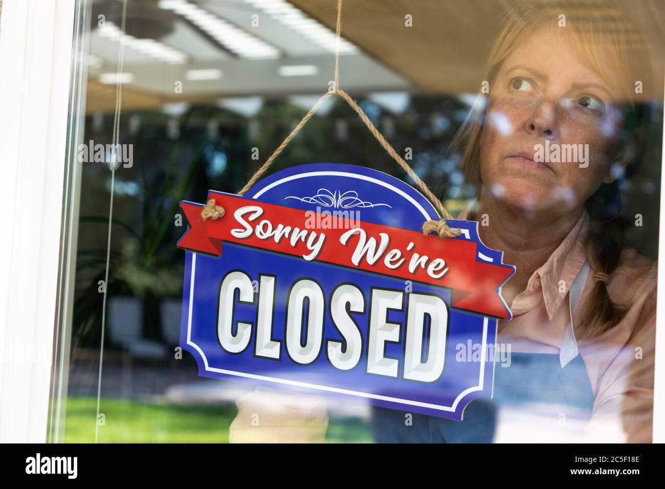 Sad Female Store Owner Turning Sign to Closed in Window Stock Photo - Alamy