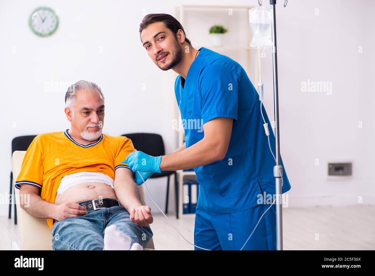 Old man visiting male doctor Stock Photo - Alamy