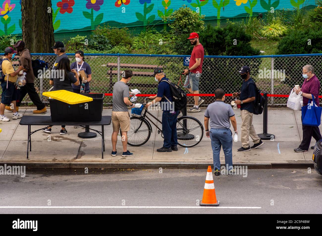 People in need line up for clothing and food at the Relief Bus social ...