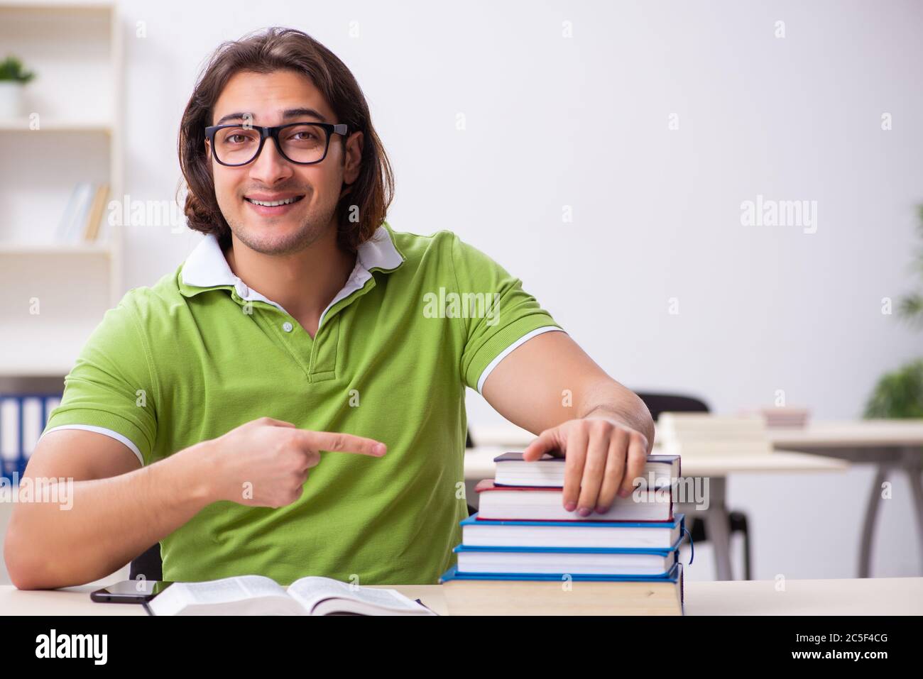 Young male student in the classroom studying Stock Photo - Alamy