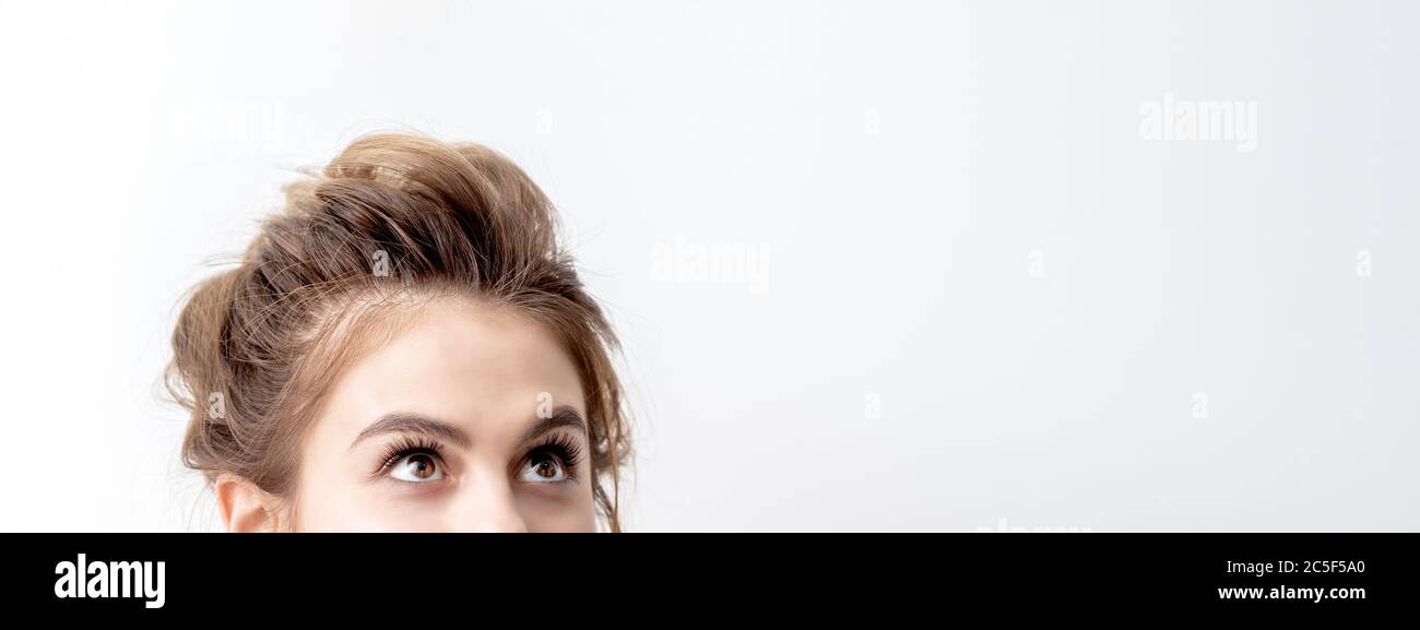 Half face of beautiful young caucasian woman looking up on white ...
