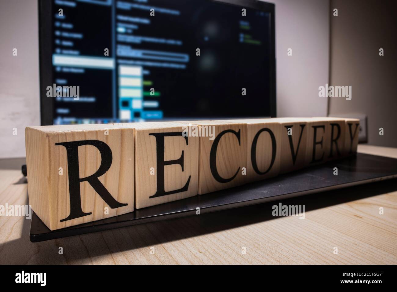 Recovery word from wooden cubes on laptop Stock Photo - Alamy
