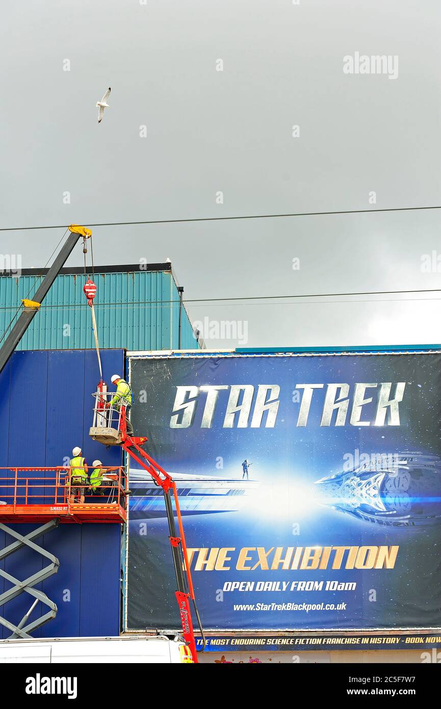 Workmen on hydraulic platforms put the finishing touches to the fronts ...