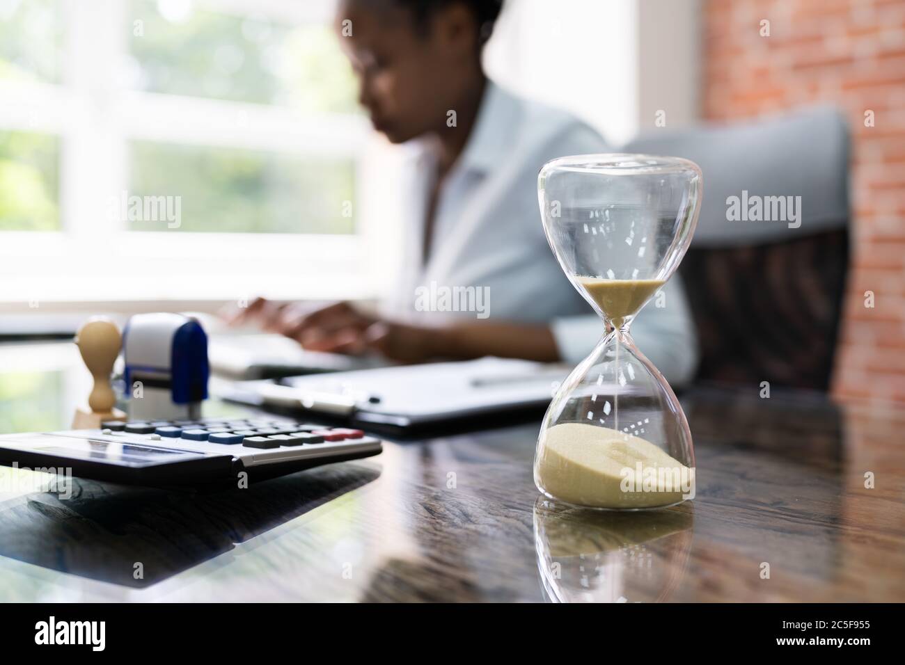 Black Accountant Woman Working With Invoice And Hourglass Stock Photo ...