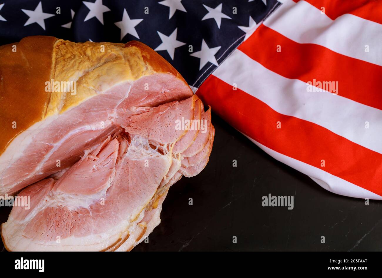 Sliced smoked whole ham in bone with american flag Stock Photo - Alamy