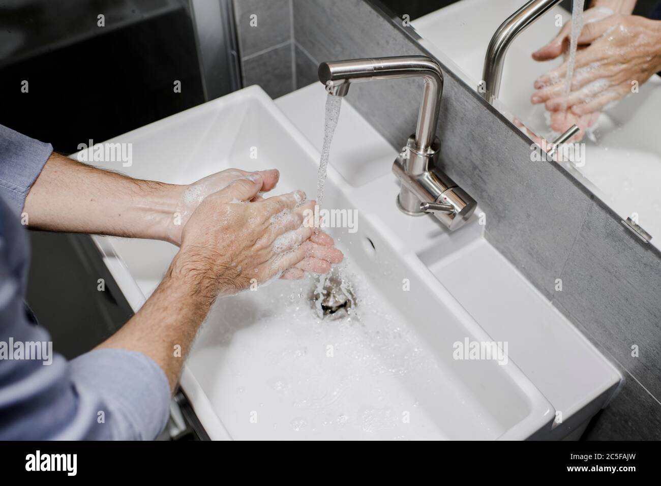 Man washing his hands at the sink Stock Photo - Alamy