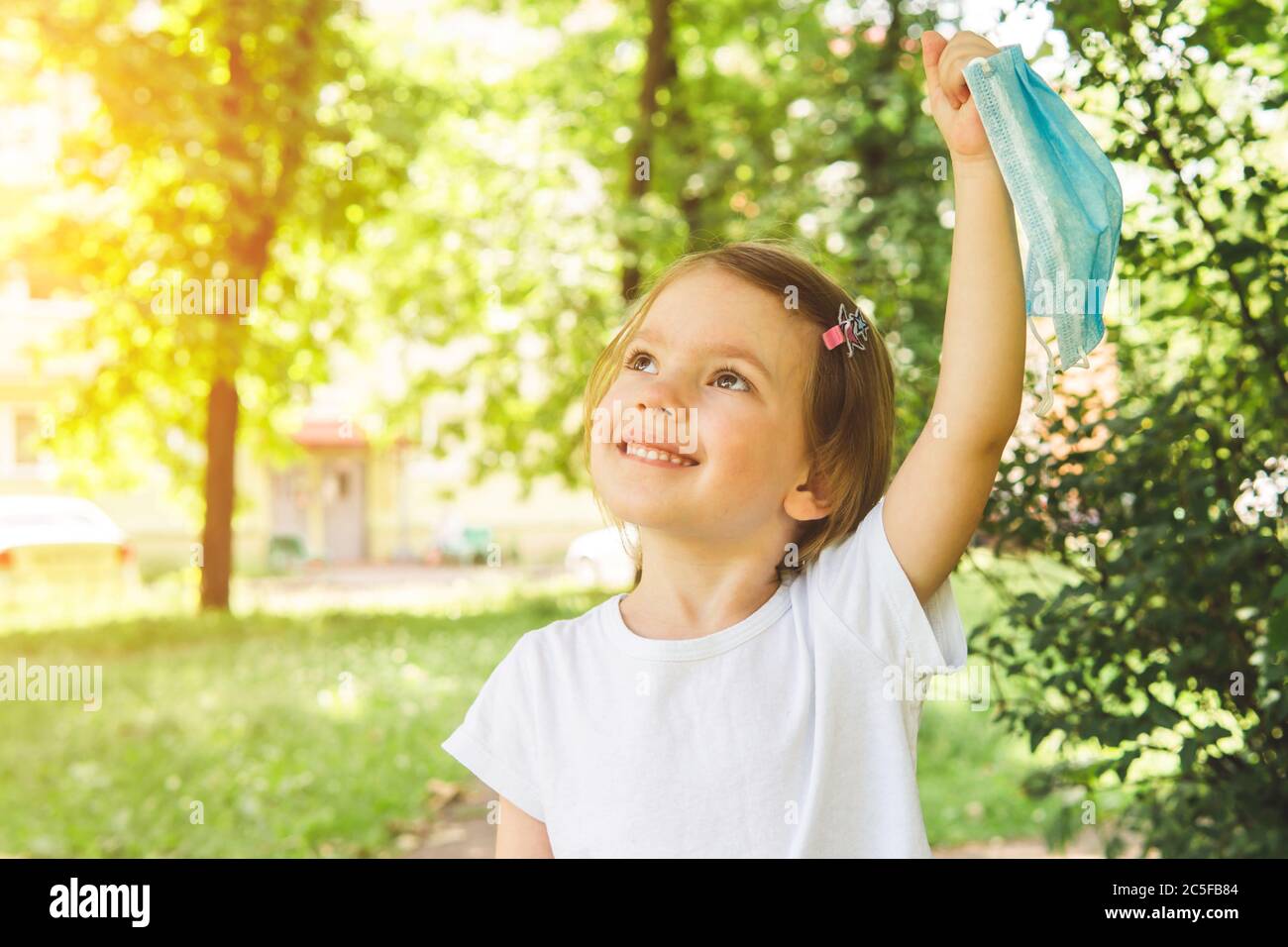 Little cute girl take off medical face mask with happy smile in the ...
