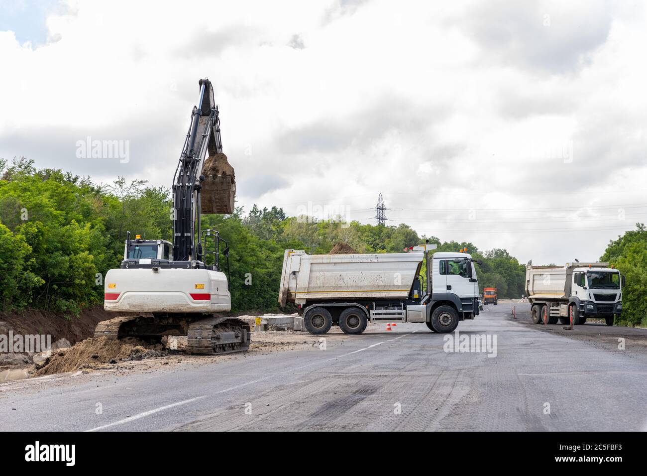 Many heavy heavy industrial road construction machinery on new highway ...